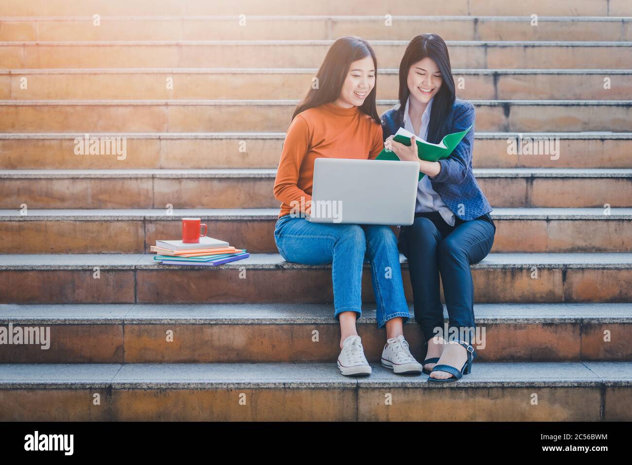 Diversity Teenagers sitting on stairs using laptop computer at the ...
