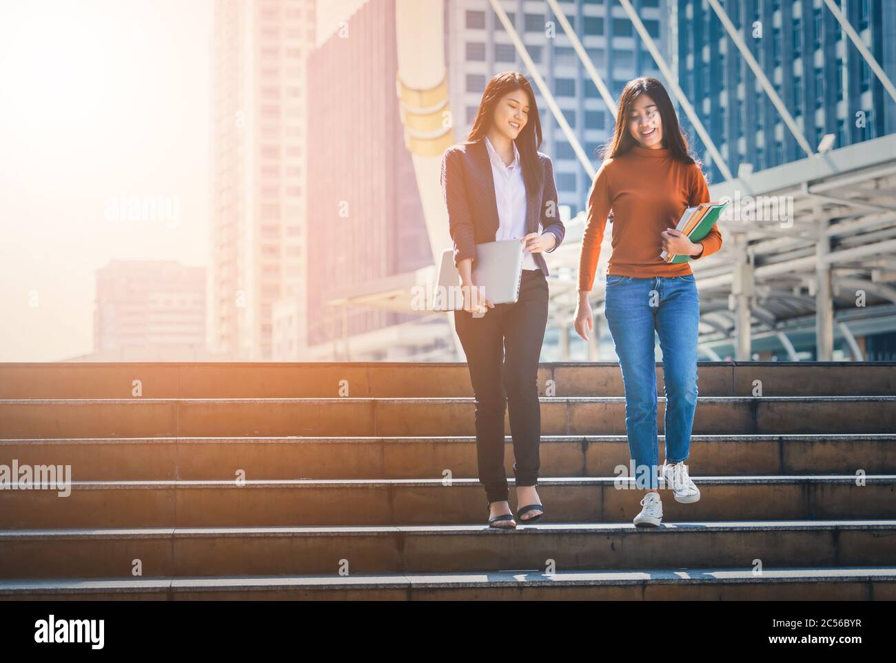 Diversity Teenagers holding laptop computer and climbing stairs go to ...
