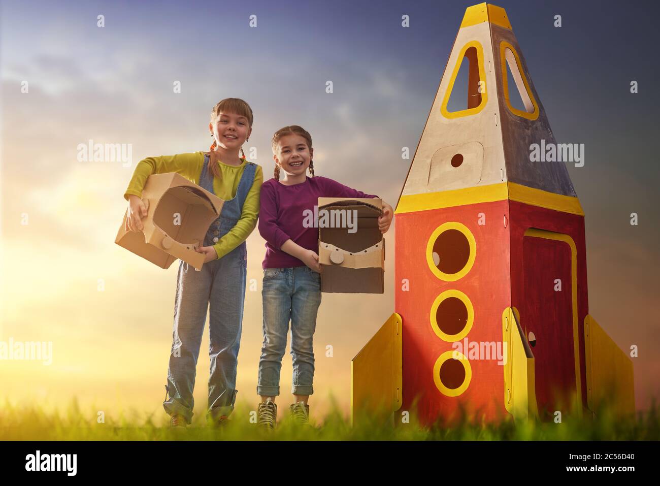 Children in astronauts costumes with toy rocket playing and dreaming of ...