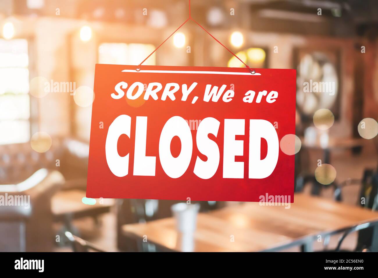 A Sign board of sorry we are closed hang on door of business shop ...