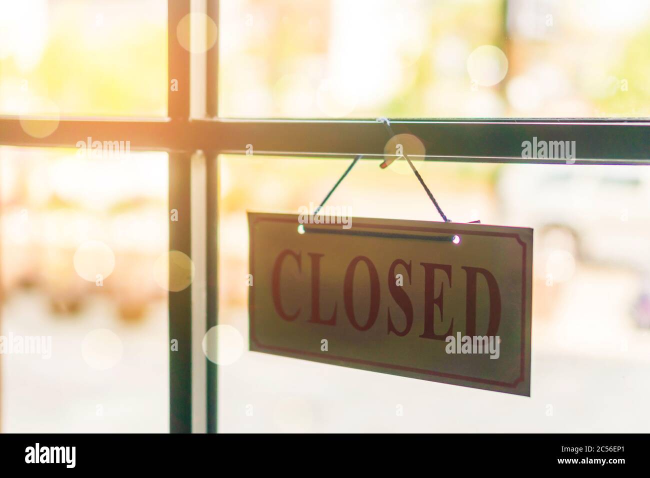 A Sign board of sorry we are closed hang on door of business shop ...