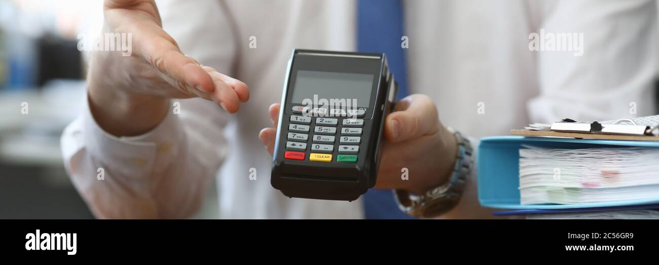 Man holds his hand wireless terminal for payment Stock Photo - Alamy
