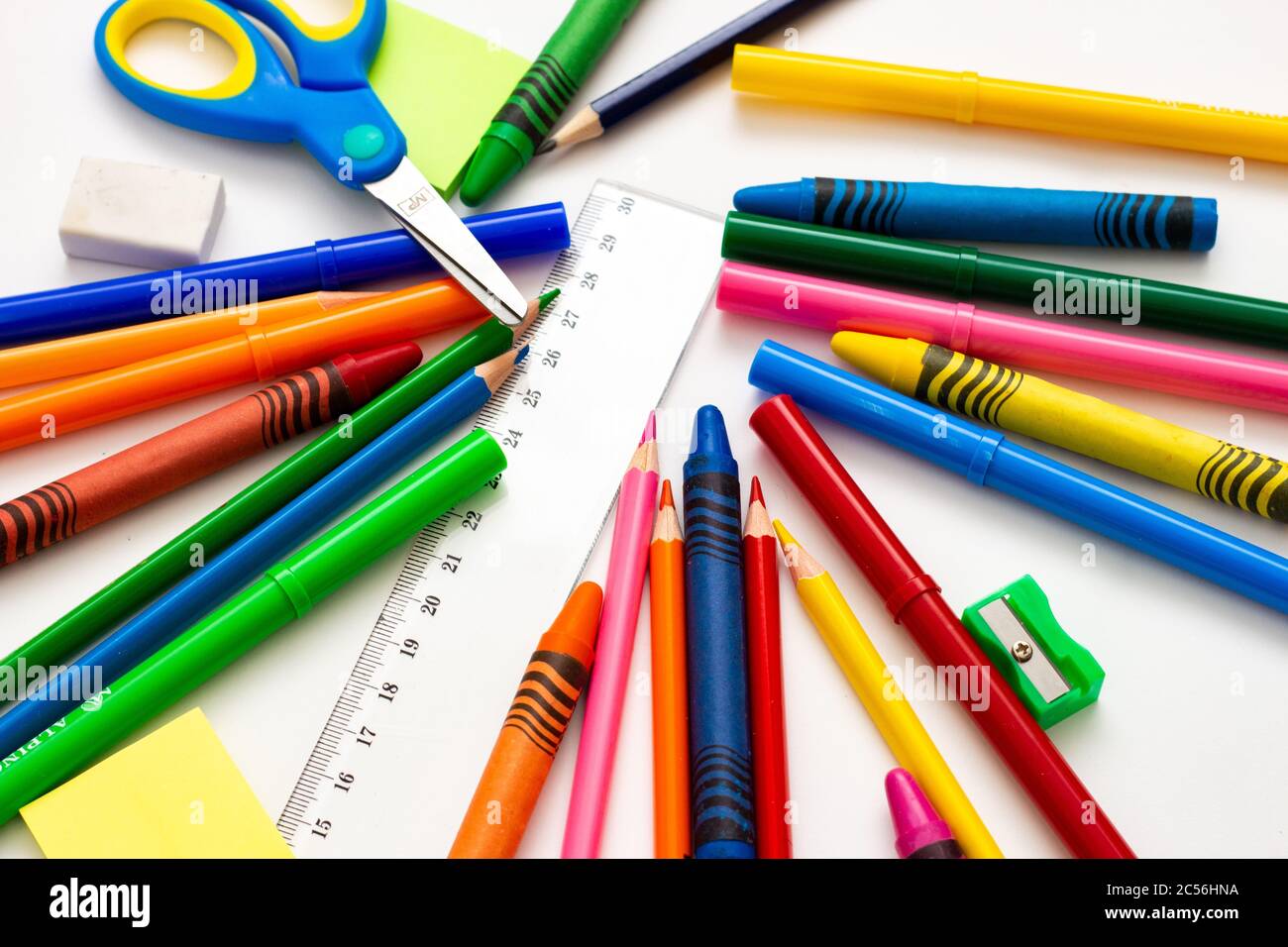 Closeup shot of colored pencils, scissor, eraser and a ruler isolated ...