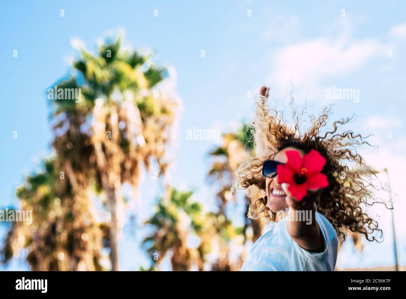 Happy free caucasian woman have fun and laugh jumping - red big flower ...