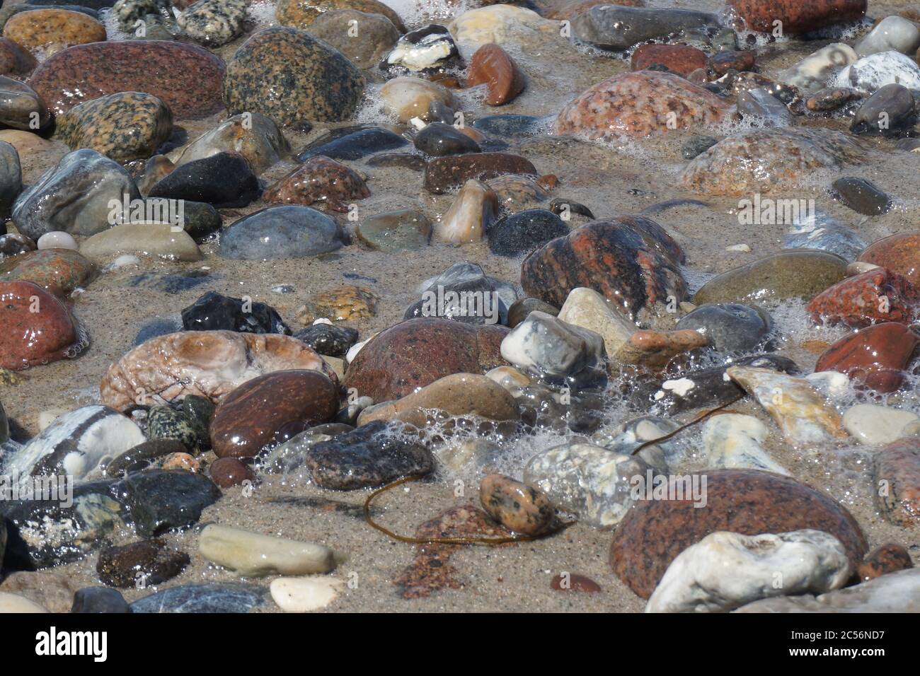 Selective shot of beach stones with waves washing up - perfect for ...