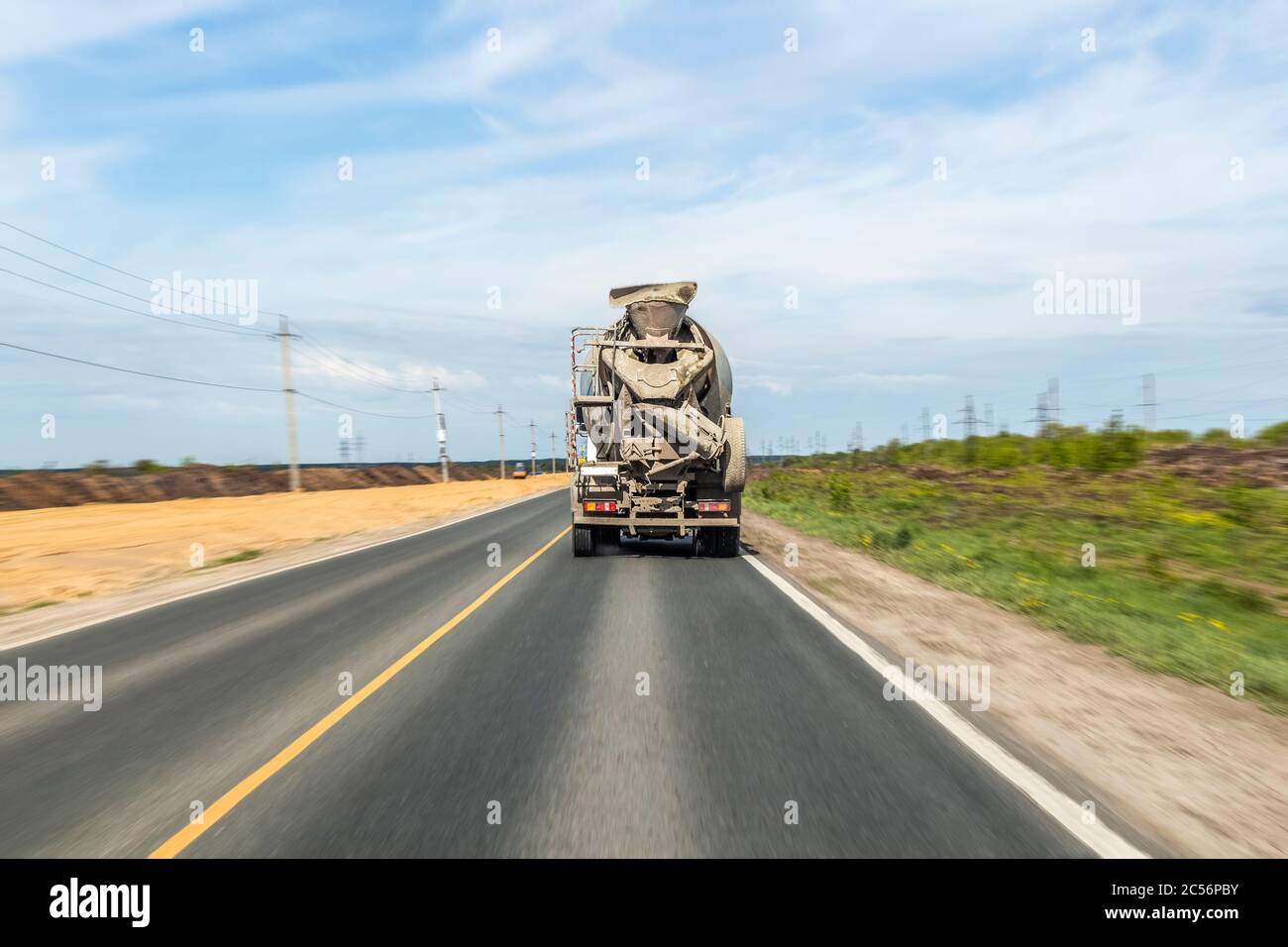 Concrete mixer rides on the road, carrying concrete to the construction ...