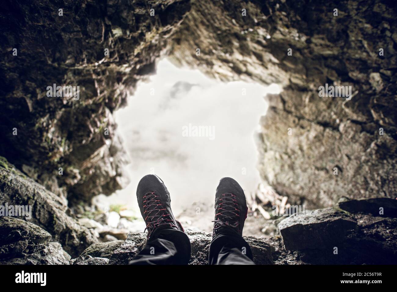 Cave inside view in the mountains. Tourist sitting inside the cave in ...