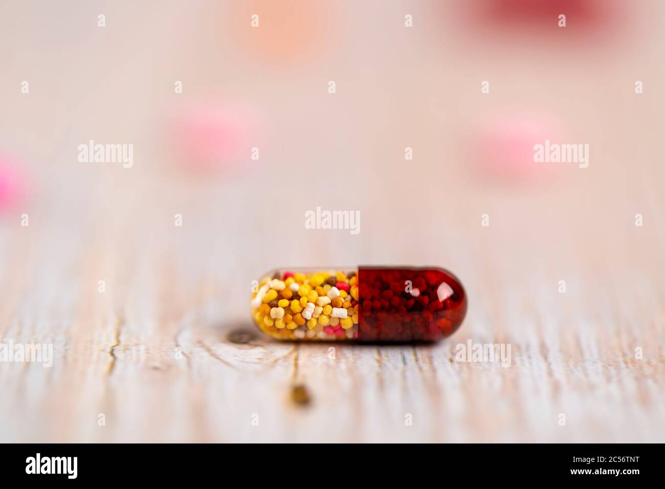 Home therapy. One red clear capsule of microgranules Stock Photo - Alamy