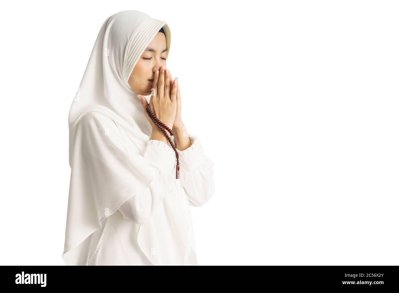 Muslim young woman praying open her arm isolated over white background ...