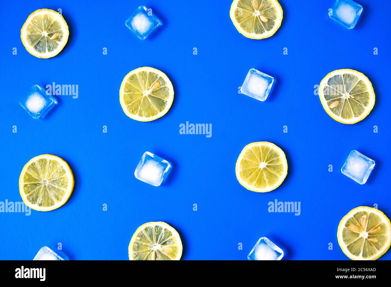 Lemonade layout with juicy lemon slices, ice cubes on blue background ...