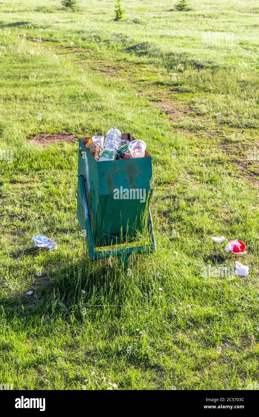Green metal trash bin on a lawn in a public park Stock Photo - Alamy