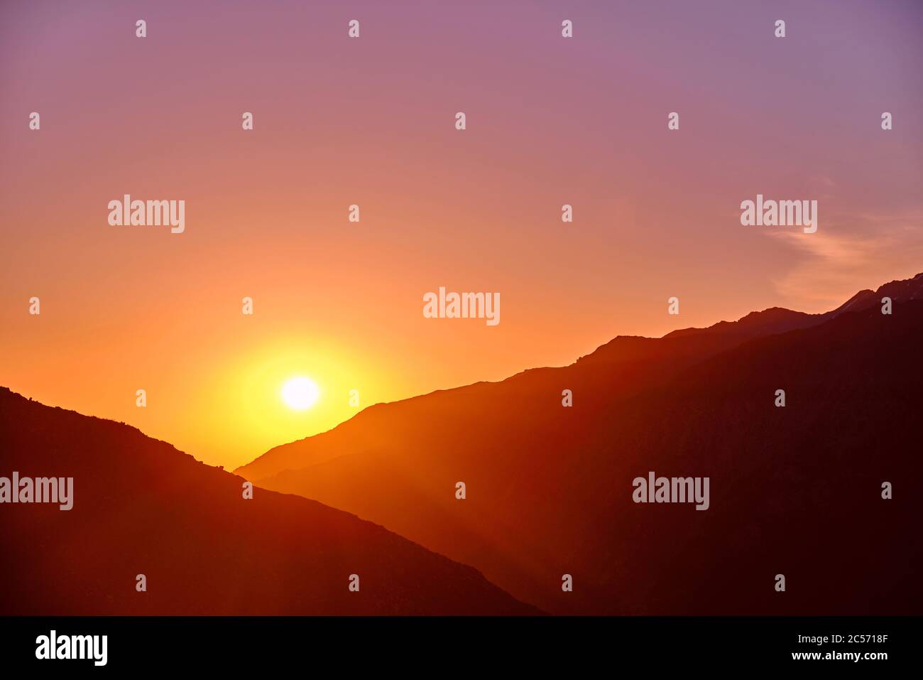 Rising sun with rays over the crests of the mountains; sunny background ...