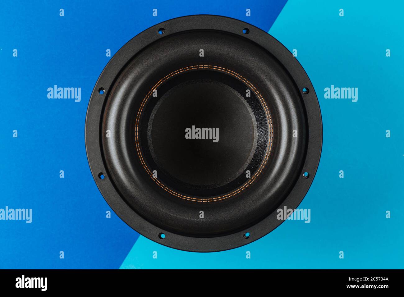 Car audio, big black subwoofer on a blue-light blue background. Close ...