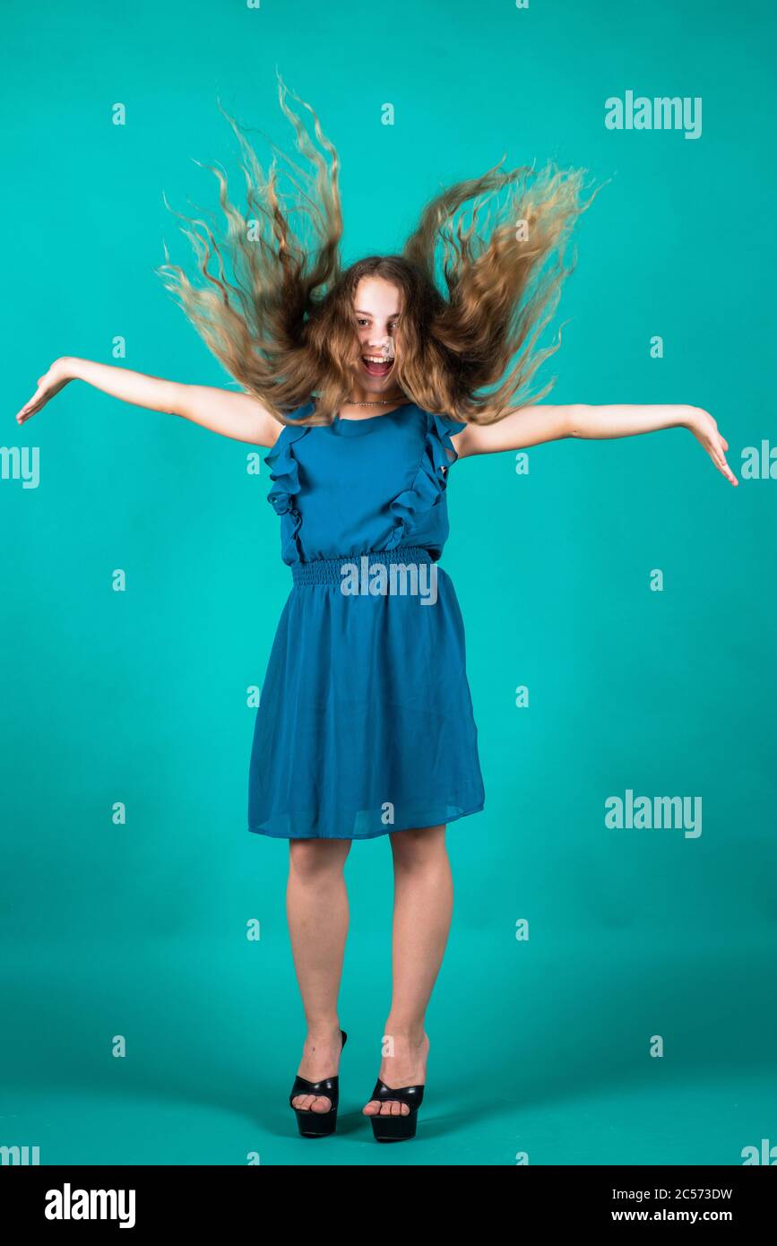 small girl has long lush hair. kid with windy curly hair in dress ...