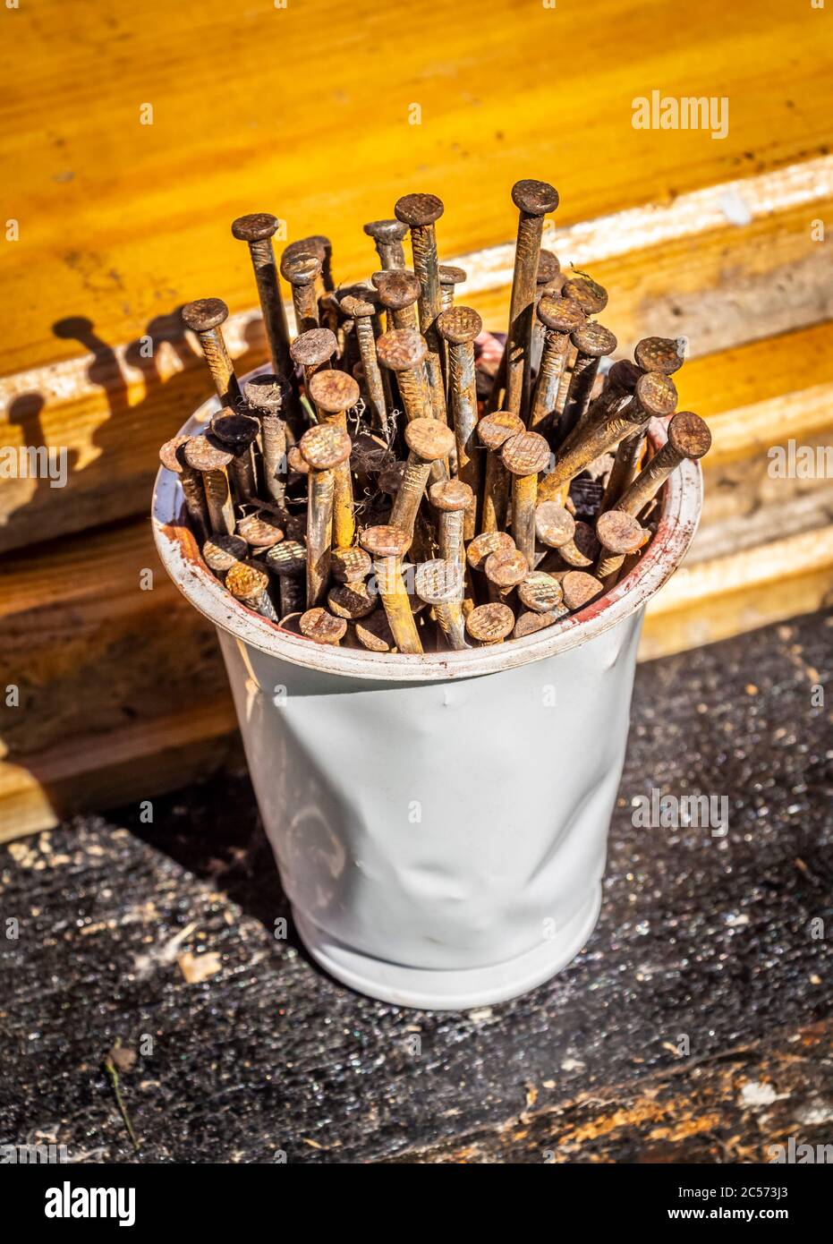 Old rusty nails in a plastic cup in the backyard Stock Photo - Alamy