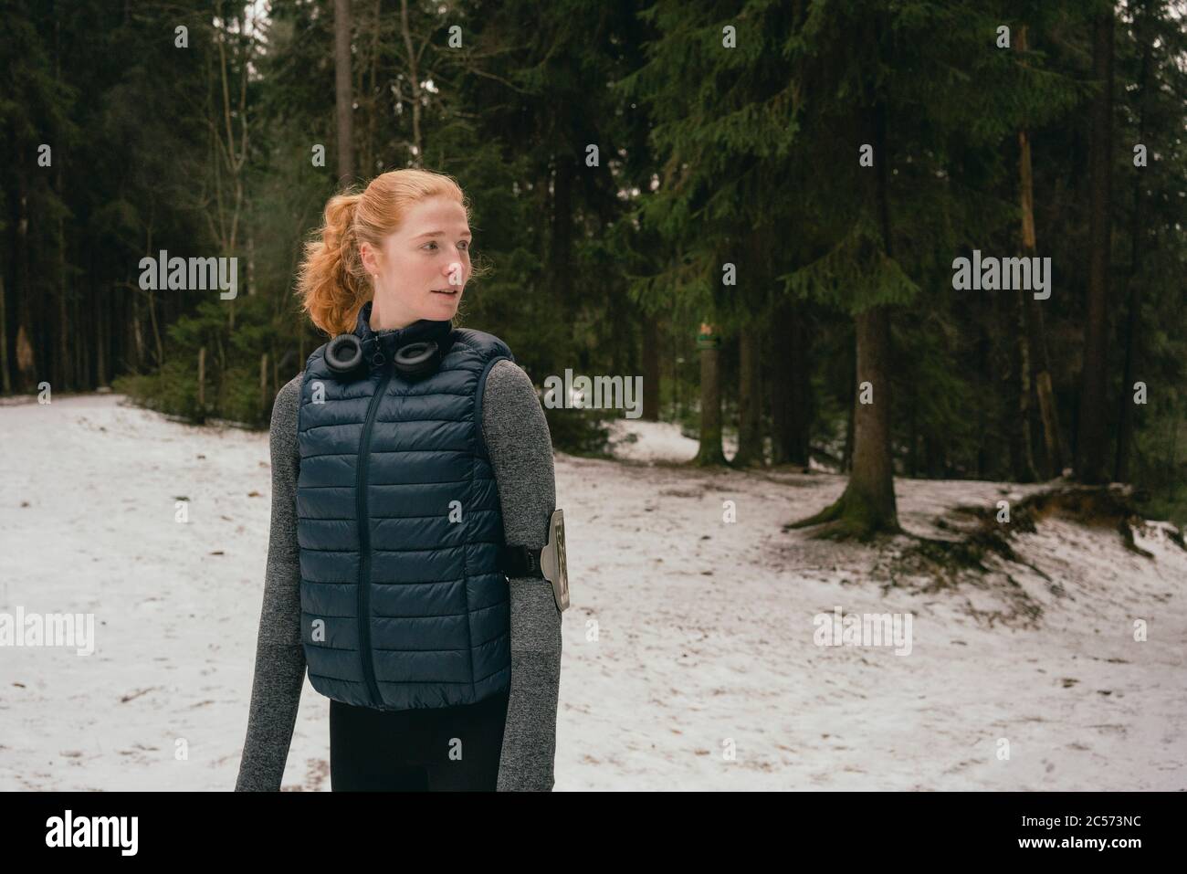 Female runner standing in snowy woods Stock Photo - Alamy