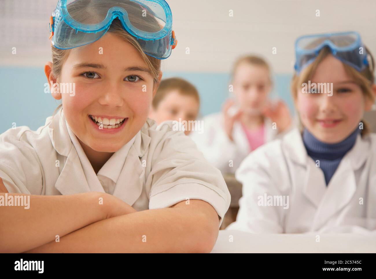 Portrait happy junior high school students in science goggles Stock ...