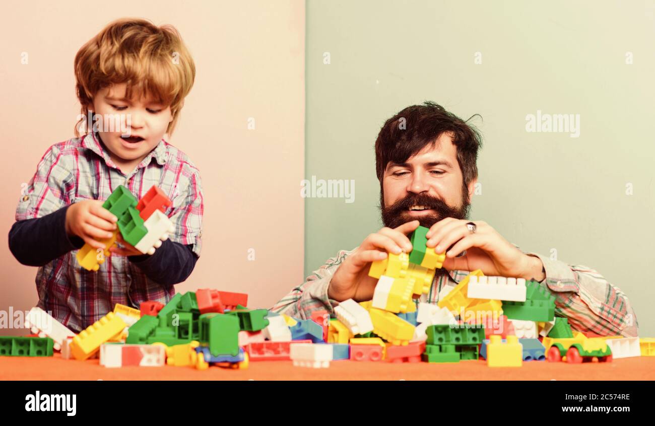 Dad and kid build of plastic blocks. Useful toy. Father and son create ...