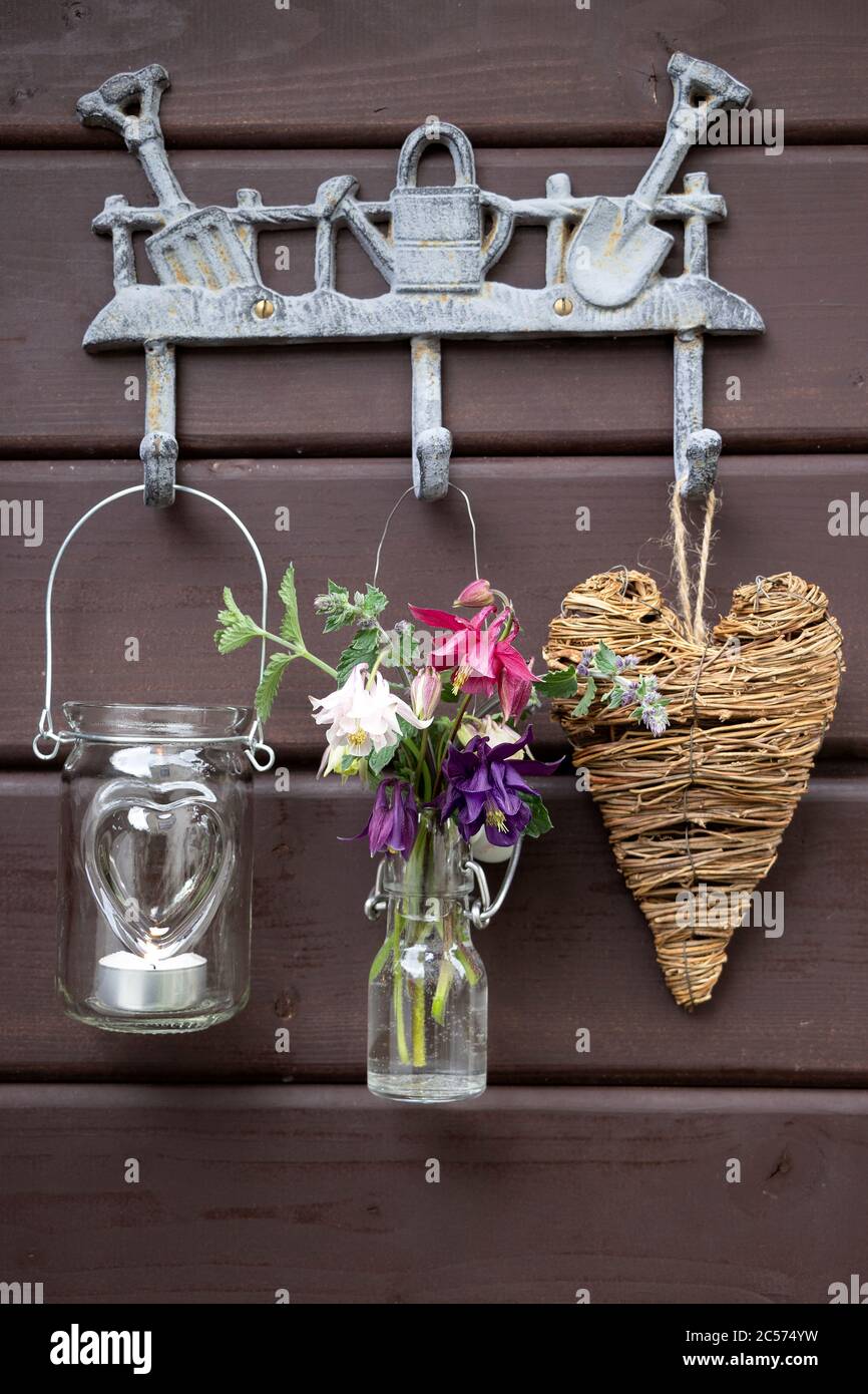 garden decoration with bouquet of columbine flowers. heart and lantern ...