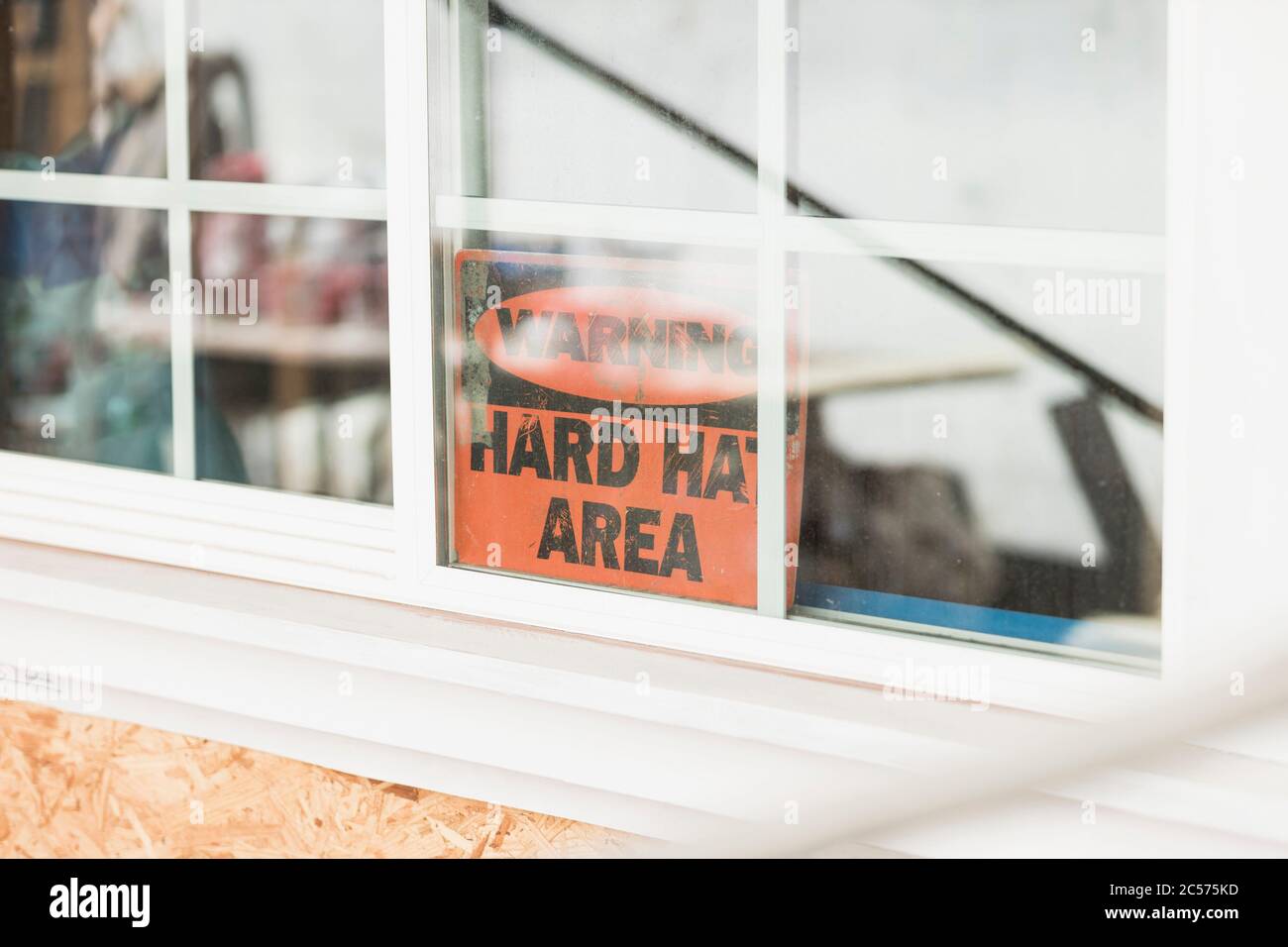 Hard hat warning sign in window at construction site Stock Photo - Alamy