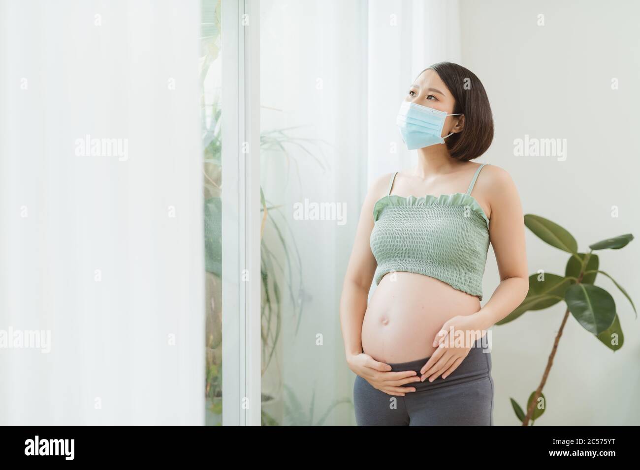 Woman in medical face mask with pregnancy test Stock Photo - Alamy