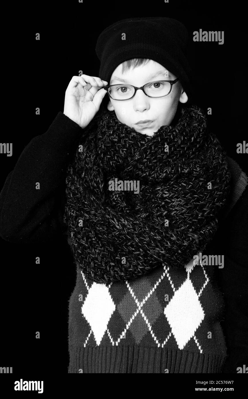 small serious boy or cute nerd kid in glasses, hat and fashionable ...