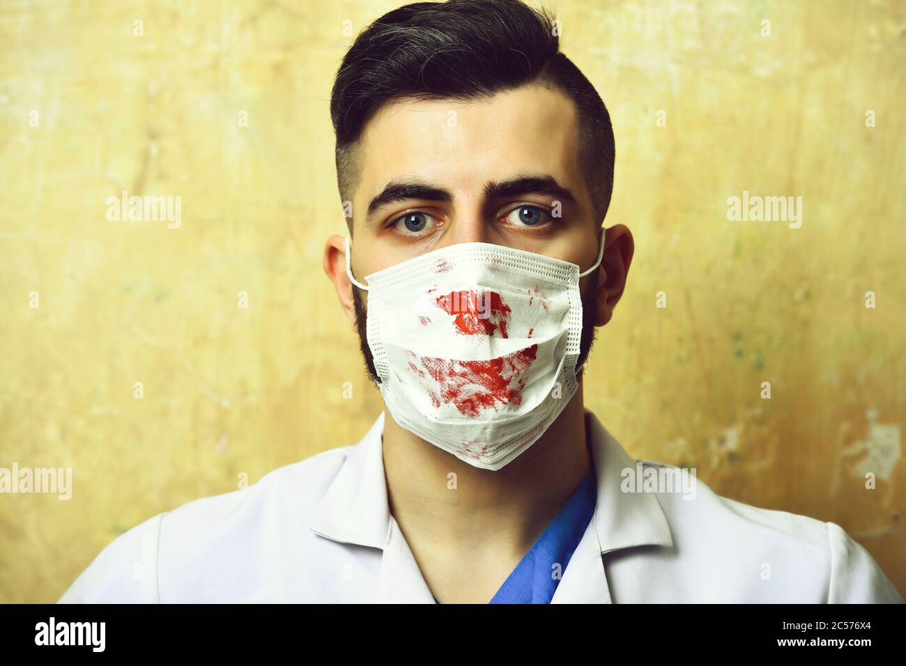 Doctor with stylish haircut and procedure mask stained with blood on ...