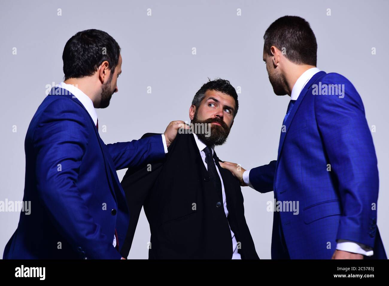 Businessmen with strict and scared faces in formal suits on grey ...