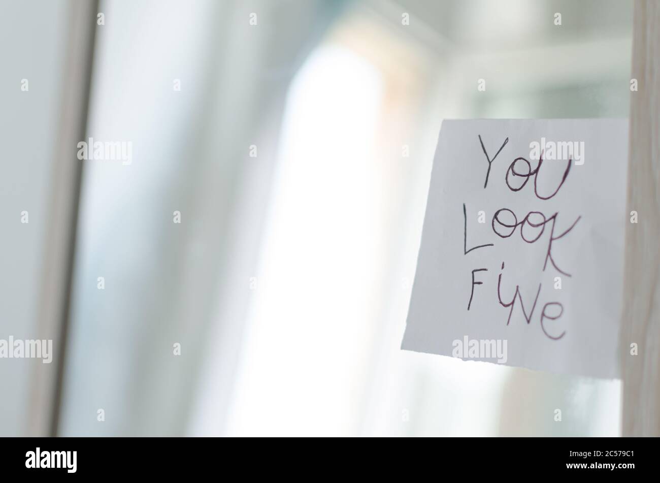 Selective focus shot of the black lettering ''You Look Fine'' on blank ...