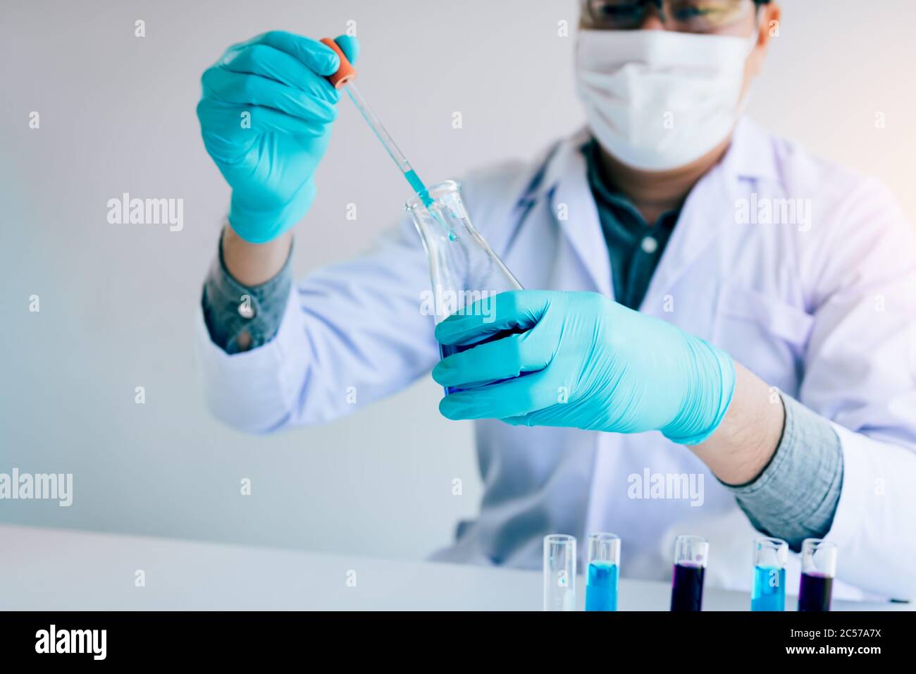 Chemist scientist conducts experiments by synthesising compounds with ...