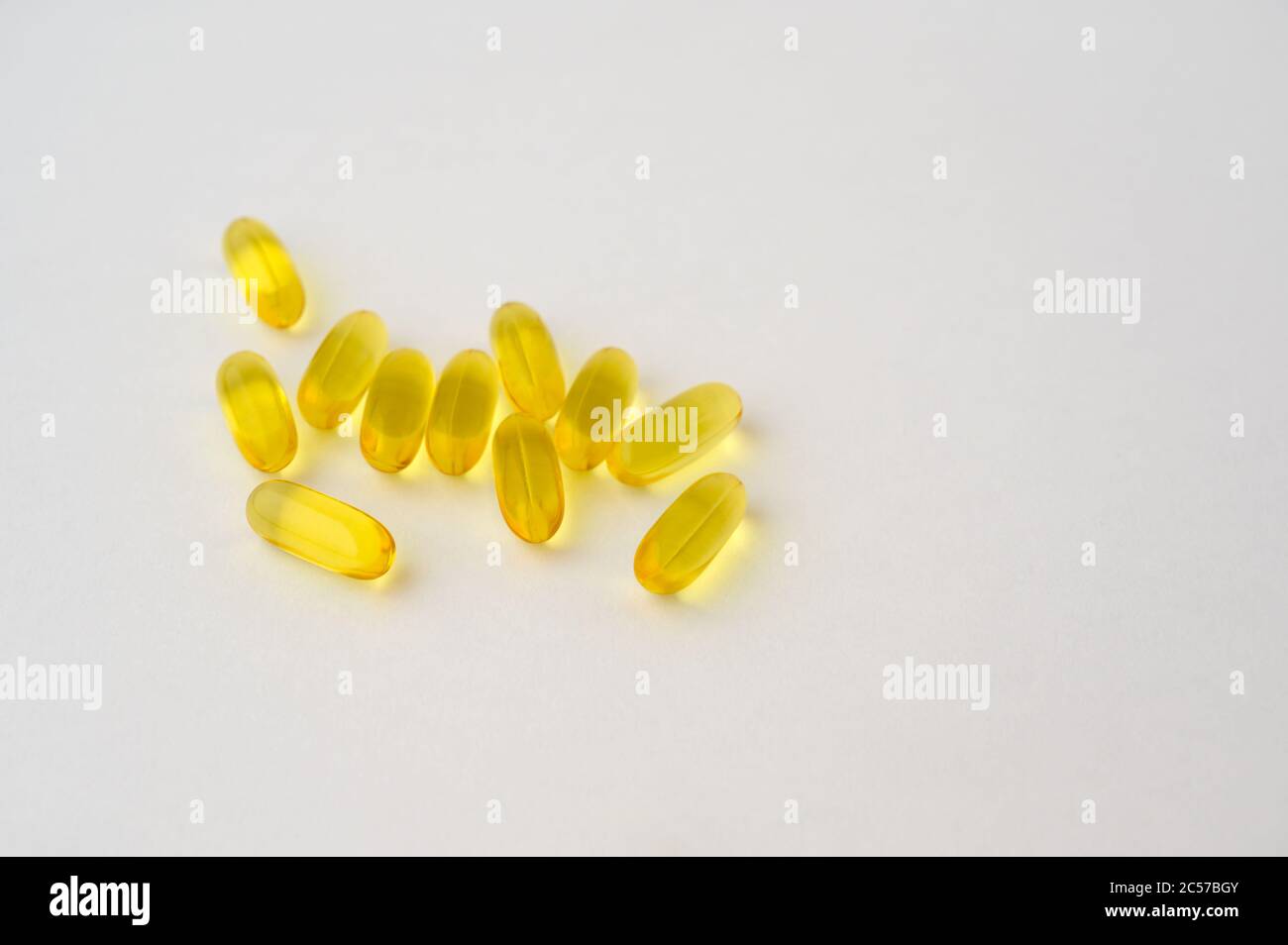 fish oil yellow transparent capsules on white background with copy ...