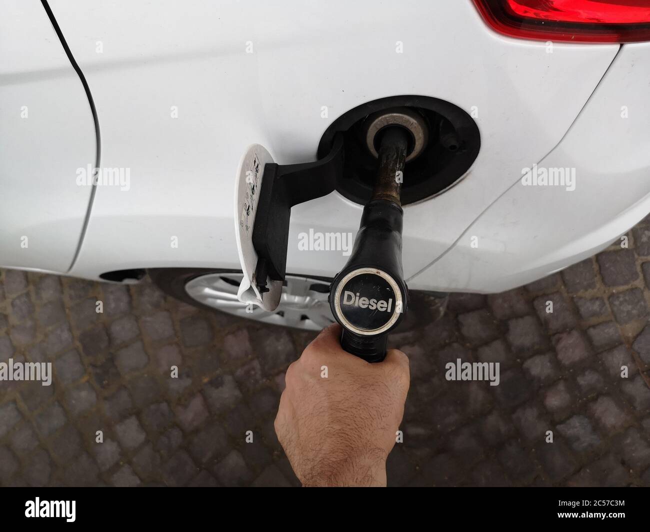 Top view of a man filling the car tank with diesel fuel at the gasoline ...