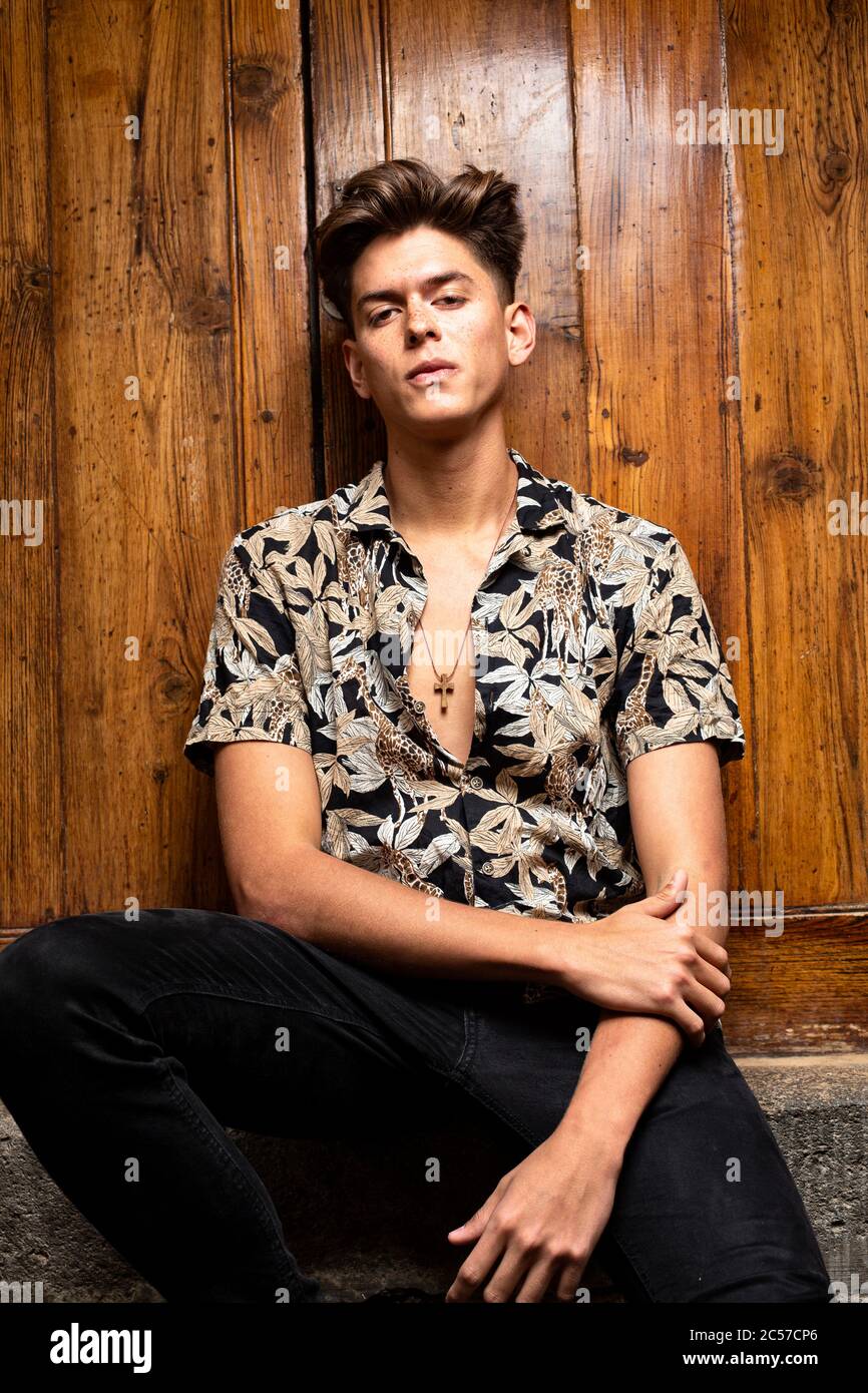 Portrait of young model with tough guy look with wooden door background ...