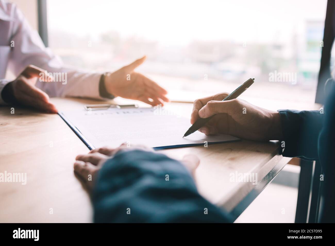 Real estate contract on desk with client signing in office Stock Photo ...