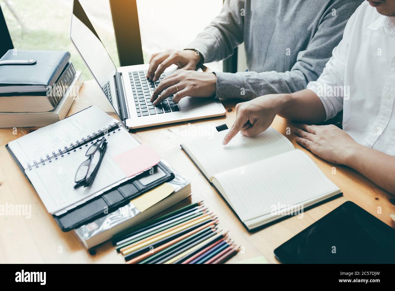 Student reading textbook for test together in library Stock Photo - Alamy