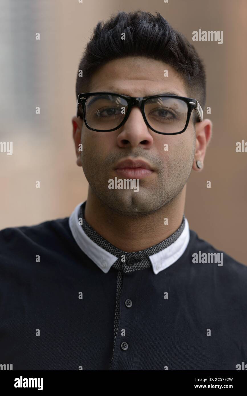 Face of young handsome Indian man with eyeglasses in the city Stock ...