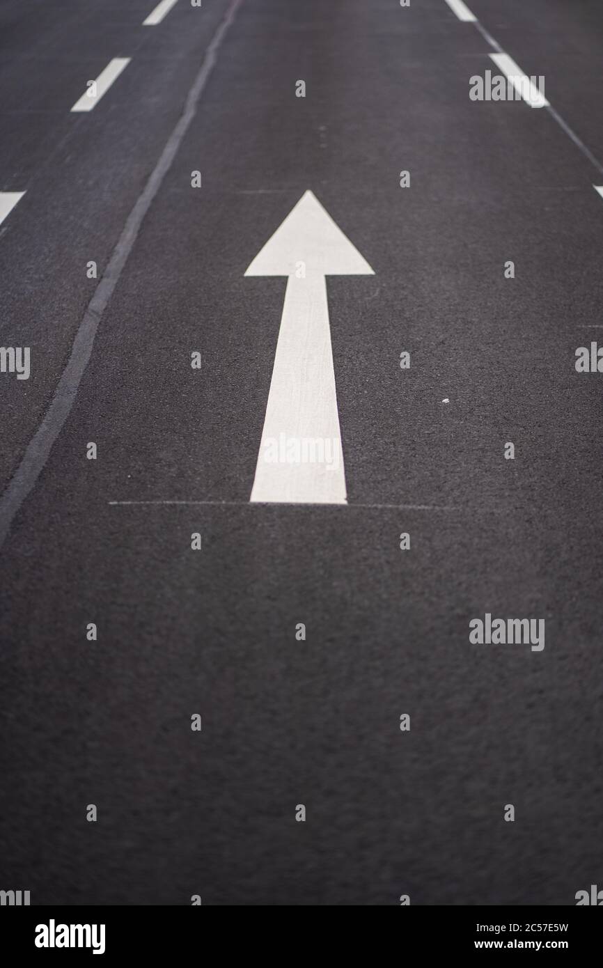 High angle shot of white arrow road signs on the asphalt ground Stock ...