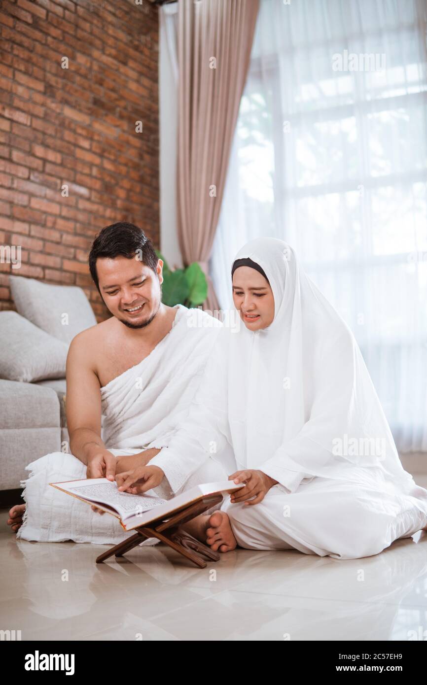 asian young couple praying with Al-Qur'an and prayer beads in white ...