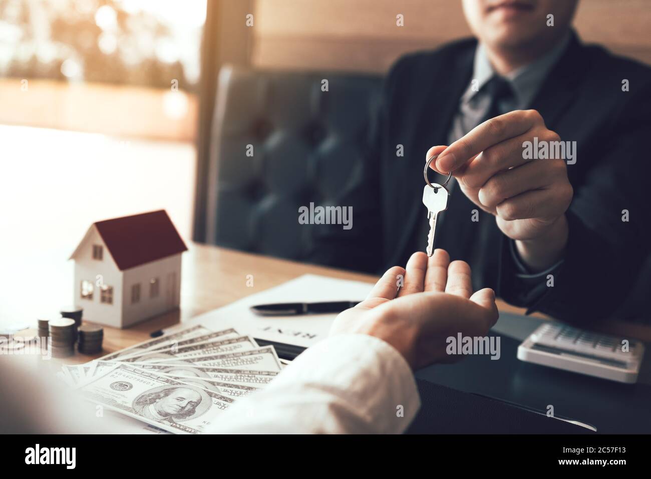 Salesman house brokers provide key to new homeowners in office Stock ...