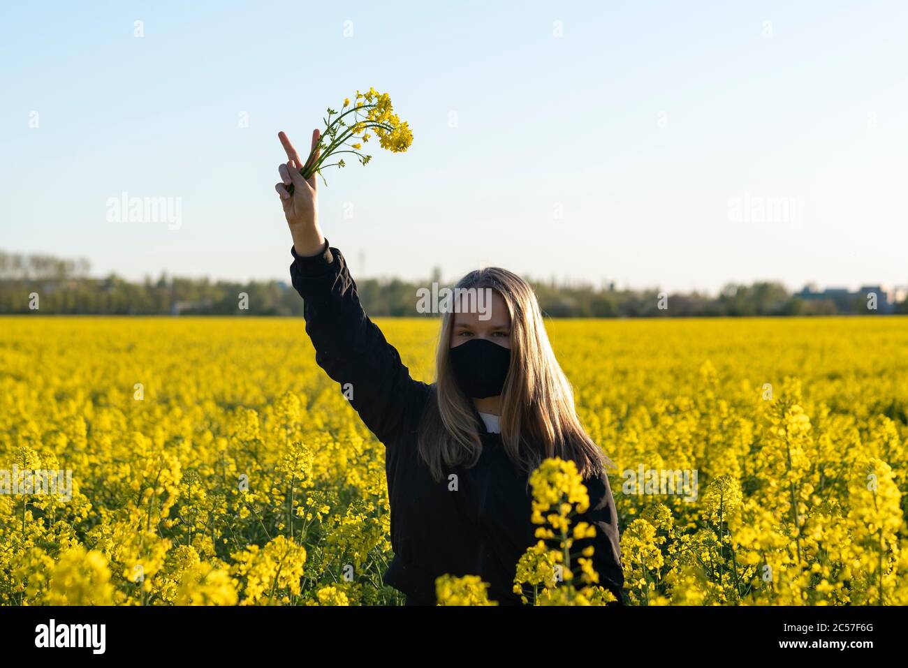 Young girl wearing a mask to protect against corona stands in a ...