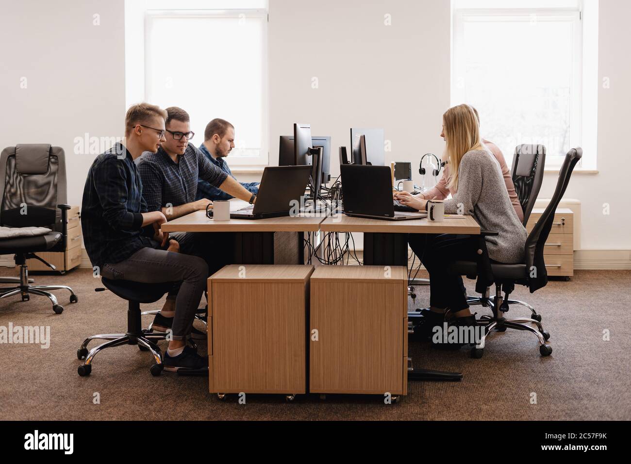 Full concentration at work. Group of young business people working and ...