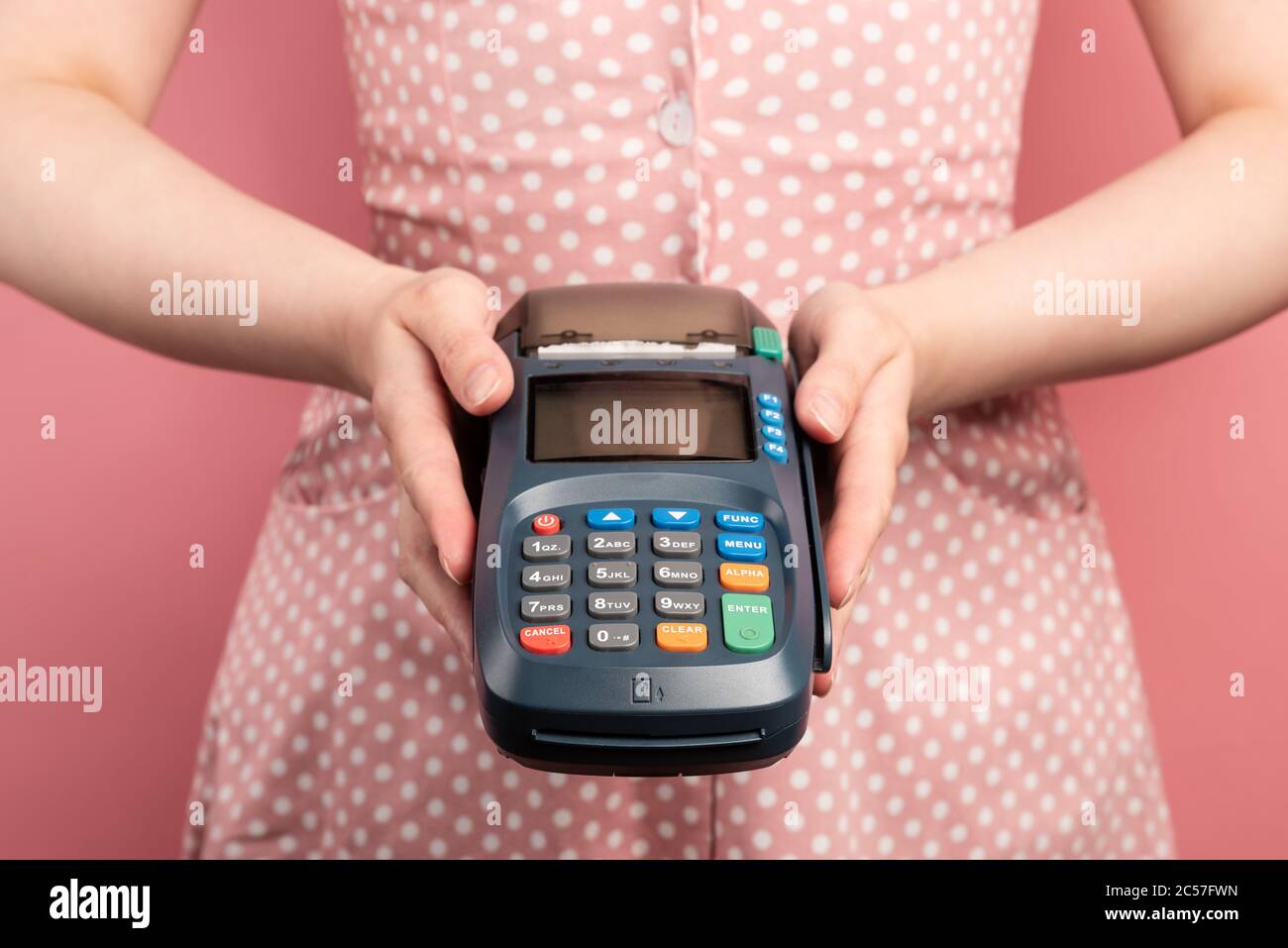Woman in a pink dress hold NFC payment contactless terminal. Credit ...