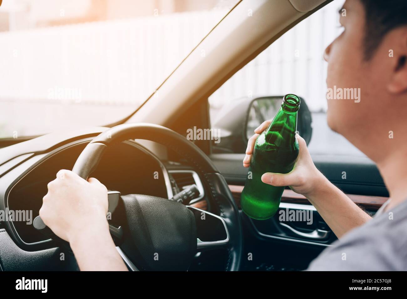 Asian men are breaking the traffic rules by holding a bottle of beer ...