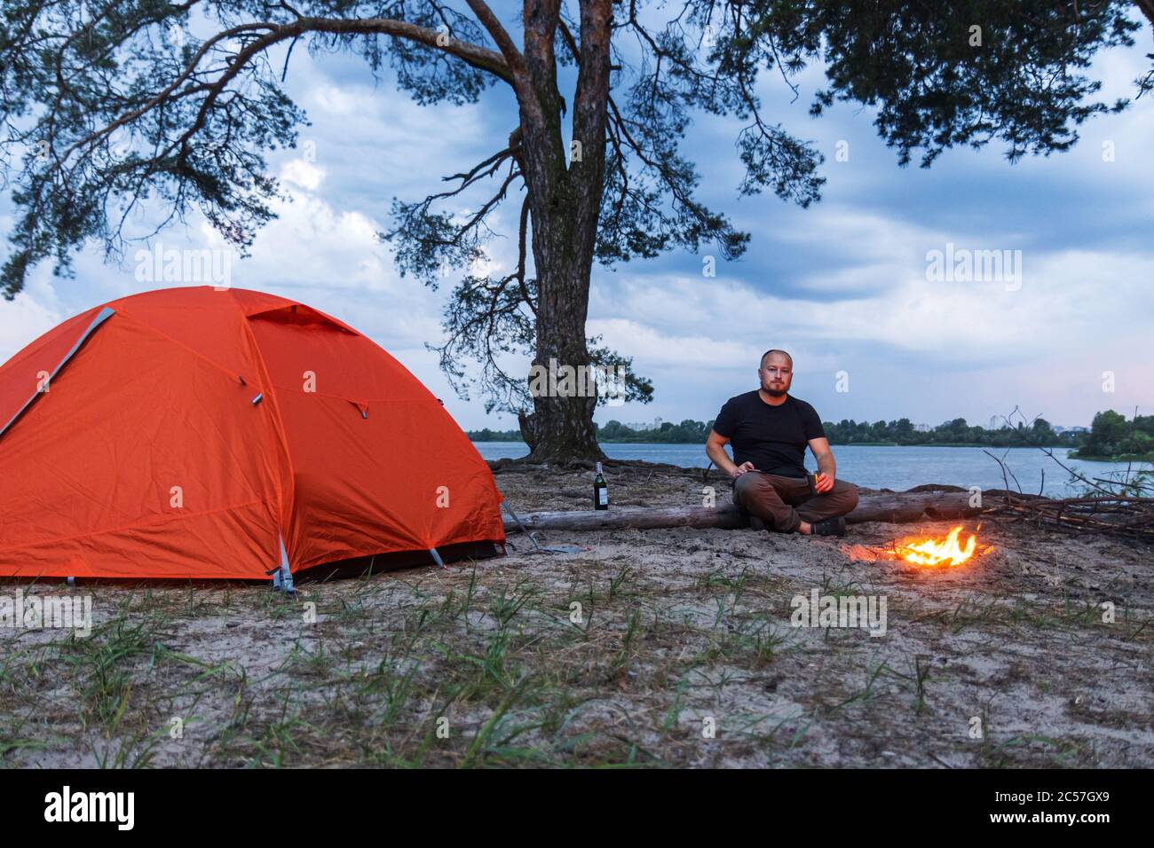 man sitting alone by the fire in the tent Stock Photo - Alamy
