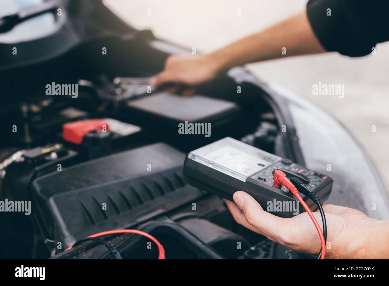 The car mechanic is carrying a battery meter and checking the general ...