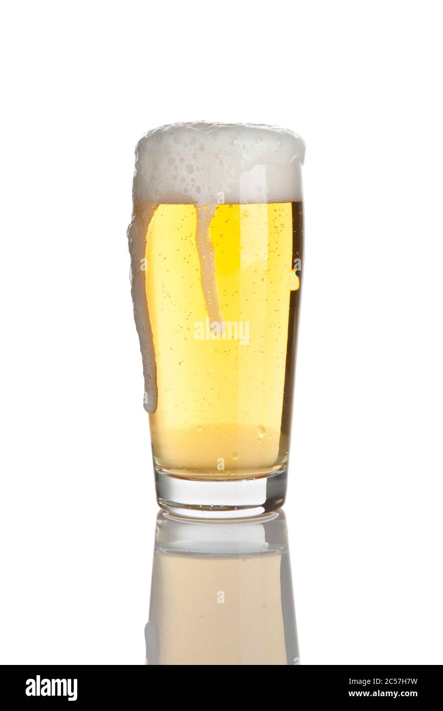 overflowing glass of fresh lager beer, froth running down, isolated on ...