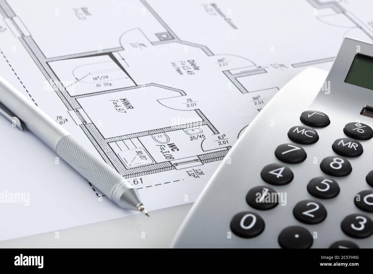 mechanical pencil and calculator on blueprint of floor plan, close up ...