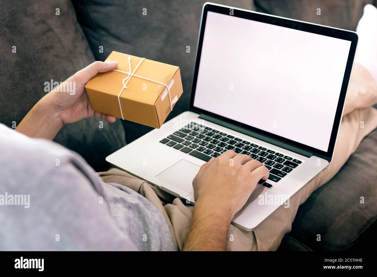 Asian man hold a delivery box for shipping and are using a laptop blank ...