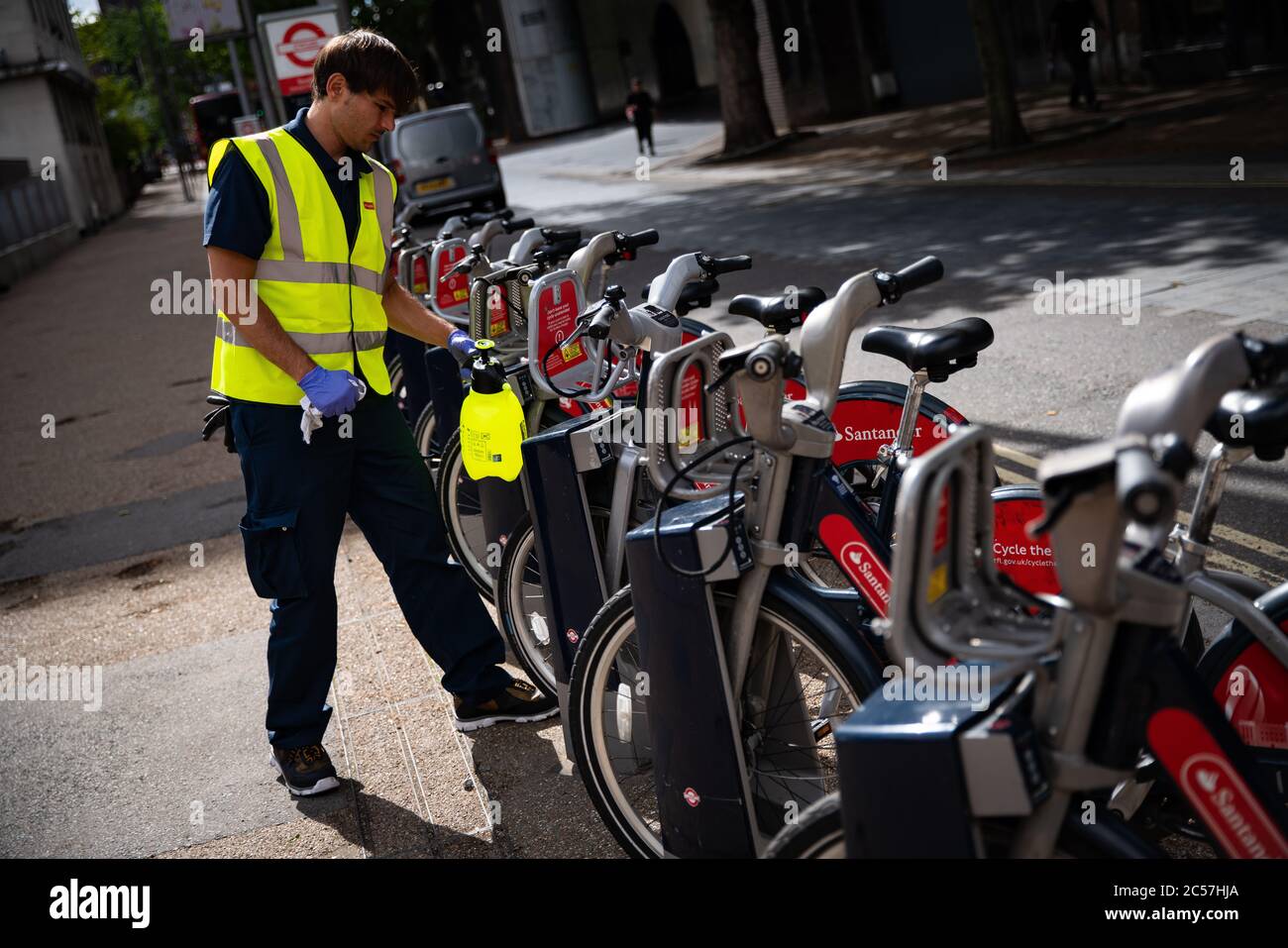 A TFL worker cleans and uses a chemical to disinfect Santander Cycles ...