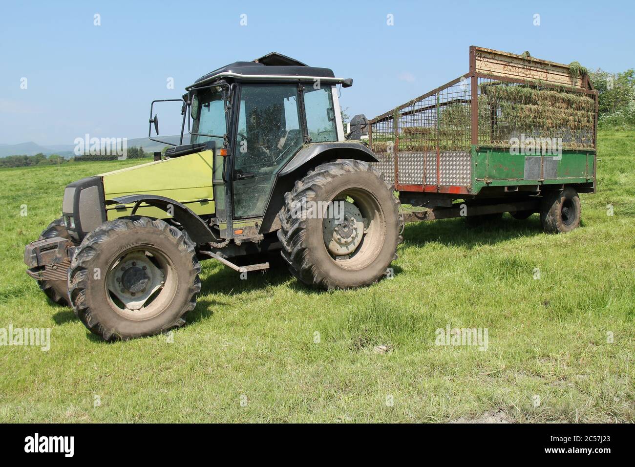 A Tractor with a Grass Collector Trailer at a Farm Stock Photo - Alamy
